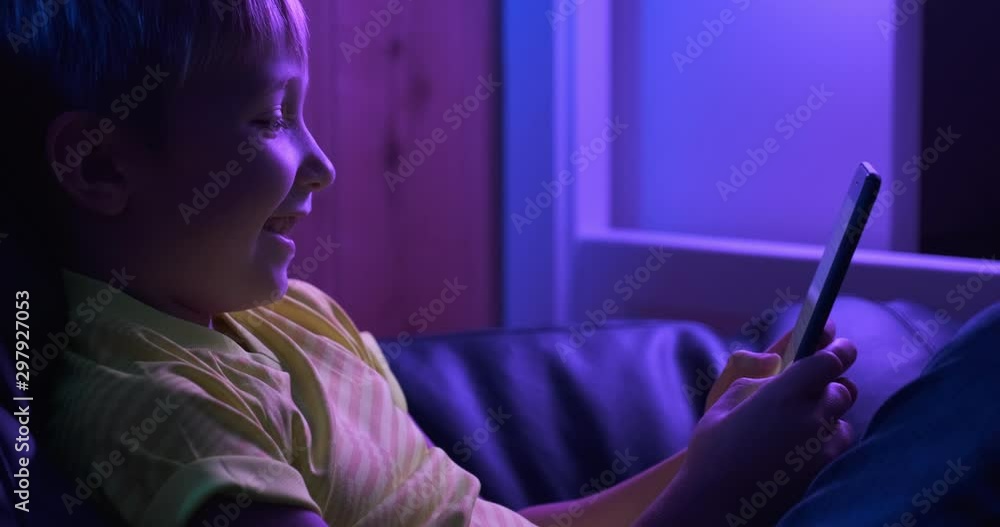 Smiling child with smartphone, 8 years old. Happy boy typing text ...