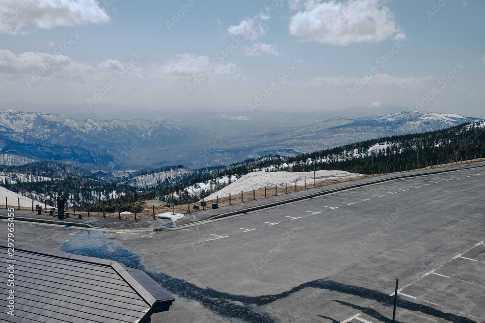 View of Mount Hachimantai, snow Iwate, asphalt road in Tohoku,Japan. Mt Iwat is the highest ...