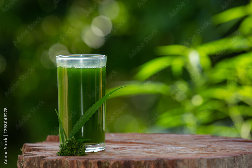 Smoothie cannabis juice that is placed on a wooden floor and has a ...