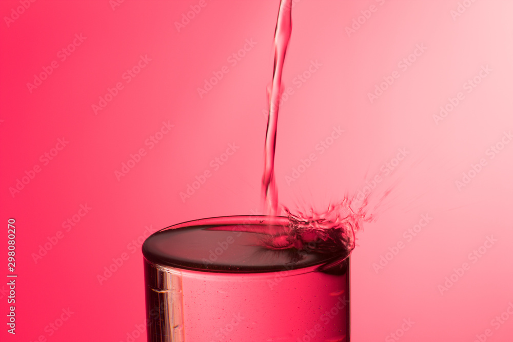 Chorro de agua llenando y rebosando un vaso de agua de cristal o ...