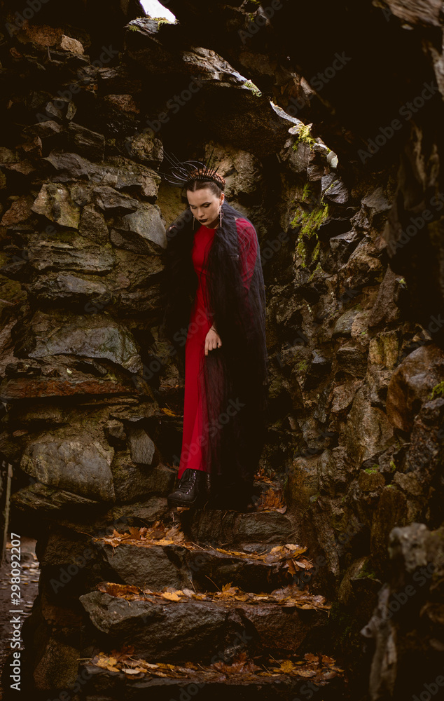 woman witch in red dress in a medieval castle.The medieval queen. Evil ...