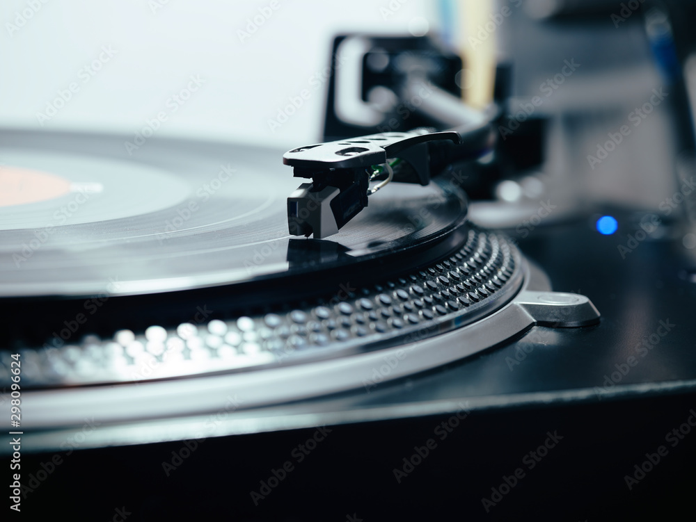 Closeup of top of old black turntable with tonearm maintaining position ...