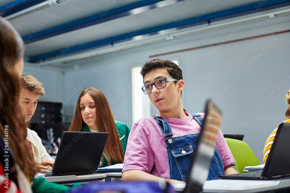 Teenage students using laptops in the classroom Stock Photo | Adobe Stock