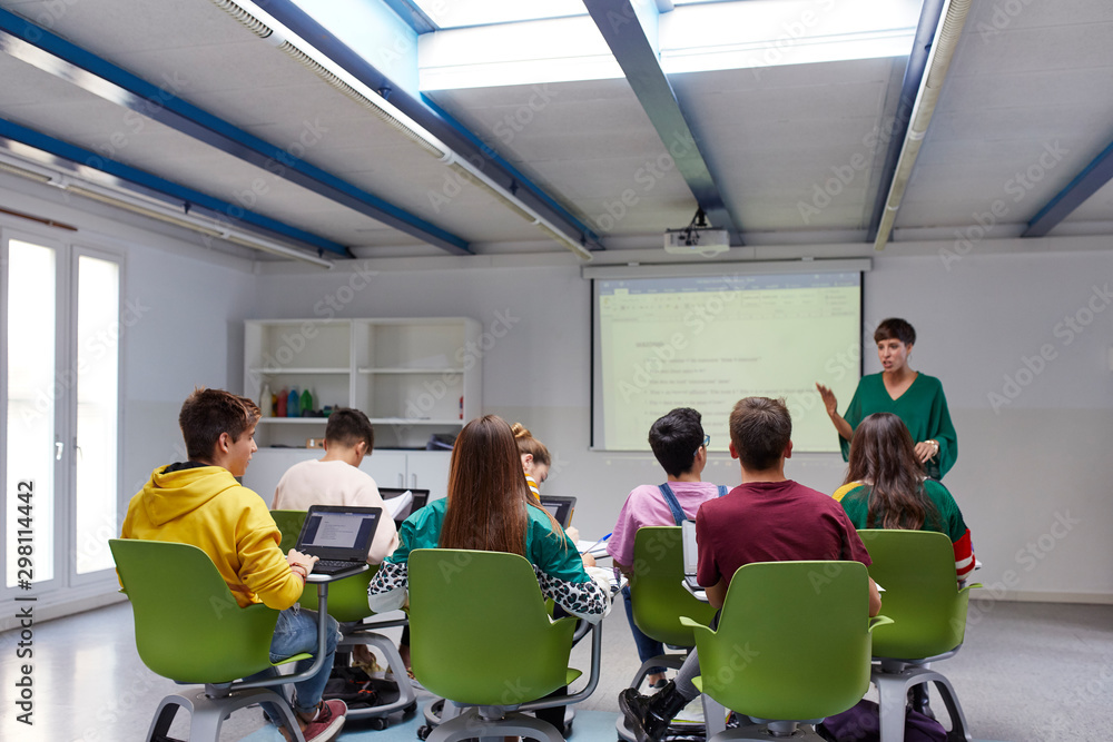 Young teacher and her students in the classroom Stock Photo | Adobe Stock