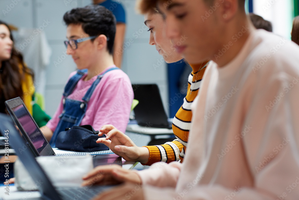 Teenage students using laptops in the classroom Stock Photo | Adobe Stock