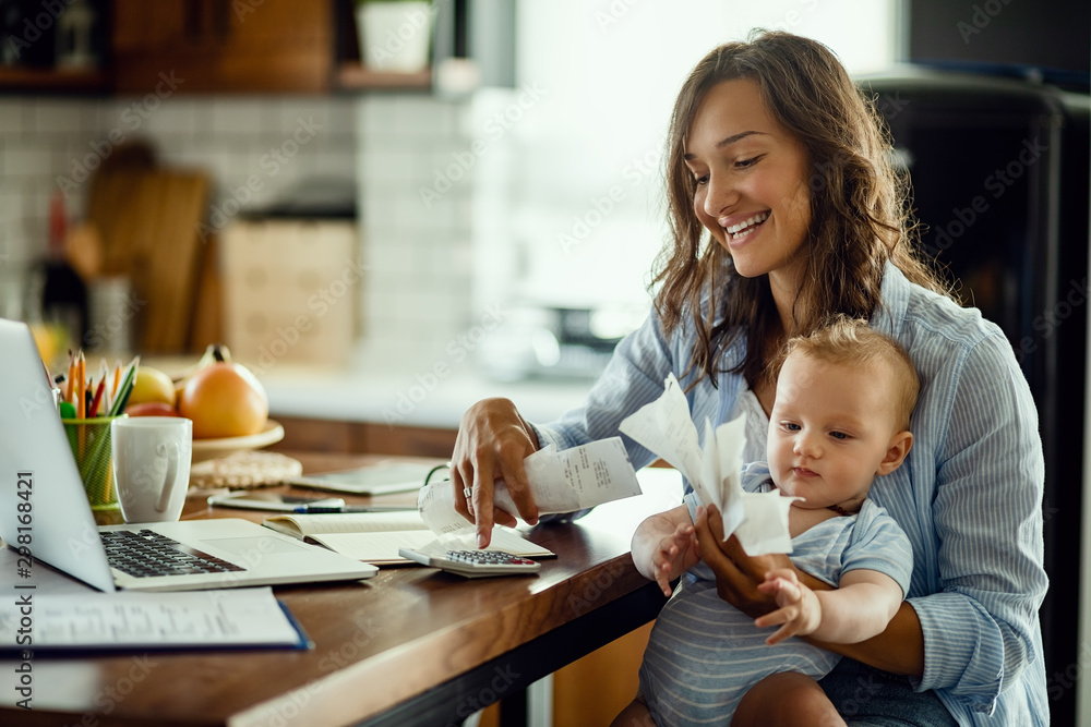 Happy mother with baby son calculating bills at home. Stock Photo ...