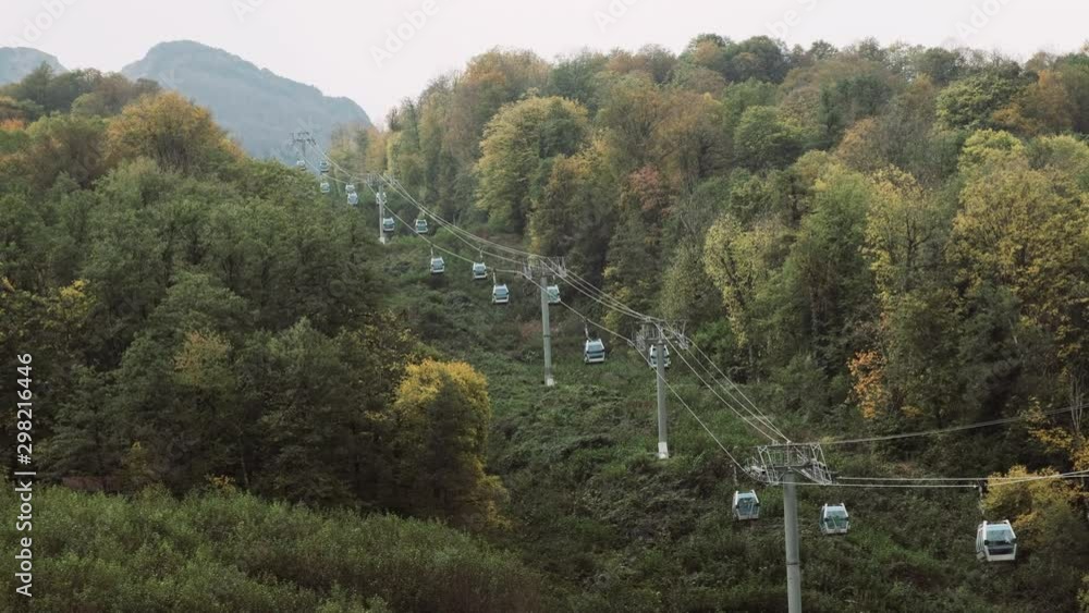 Cable car lifts tourists in luxury mountain resort in summer. Wide-shot ...
