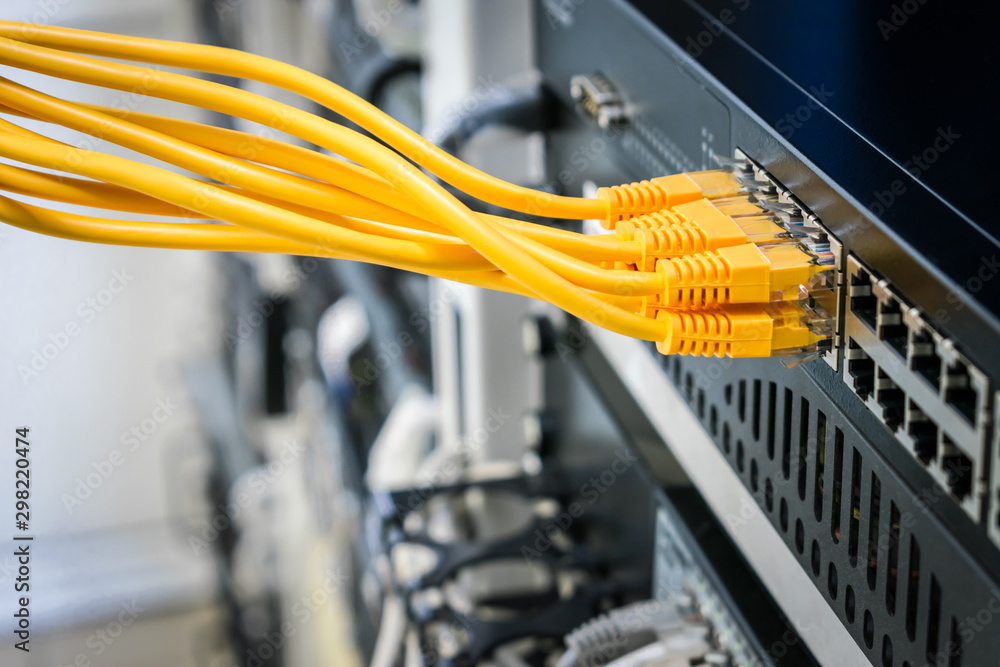 Many yellow internet wires connect to the network switch in the server ...