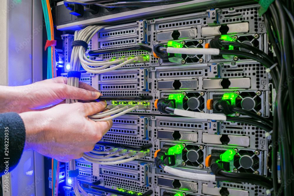 Service work in the datacenter server room. The hand of a technician ...