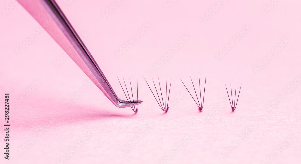 Bunches of fake lashes and tweezers on pink background. Eyelash ...