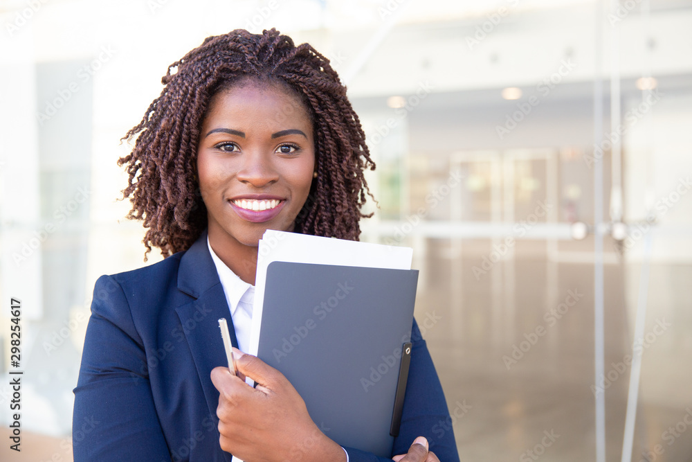 Foto de Happy friendly office assistant posing outside. Young black ...