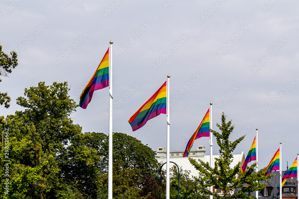 Six rainbow colored pride flags on flag poles Stock Photo | Adobe Stock