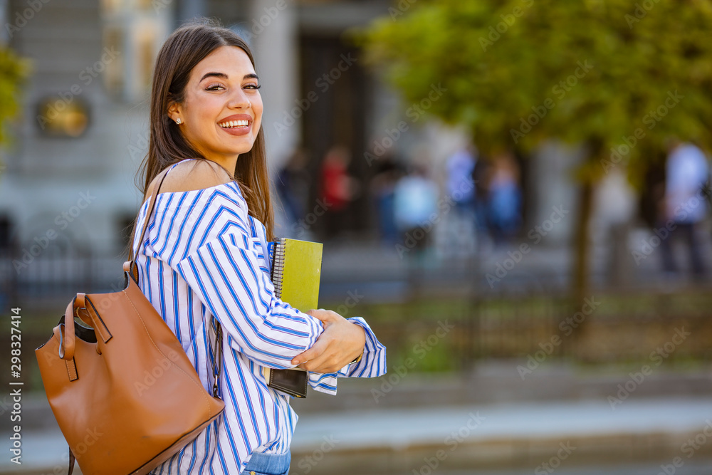 Smart female college student on campus outdoors. Portrait of a cute ...