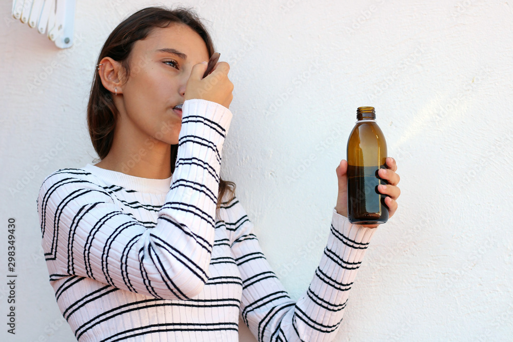 Young woman taking a cough syrup Stock Photo | Adobe Stock