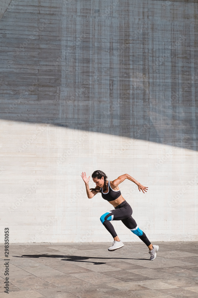 Female athlete running on concrete vertical Stock Photo | Adobe Stock