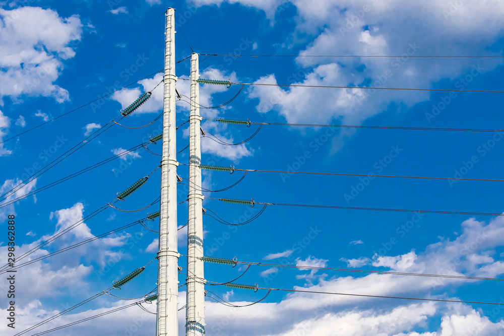 Scattered clouds are seen behind a high electric pylon with copy-space ...