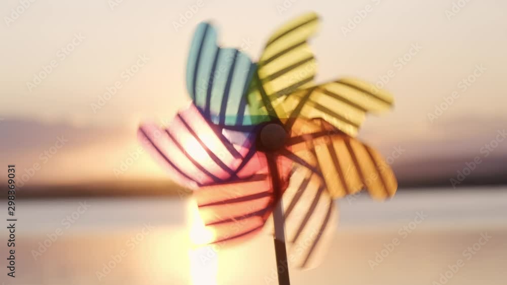 Rotate plastic pinwheel rotate with a blowing wind stands on sand by ...