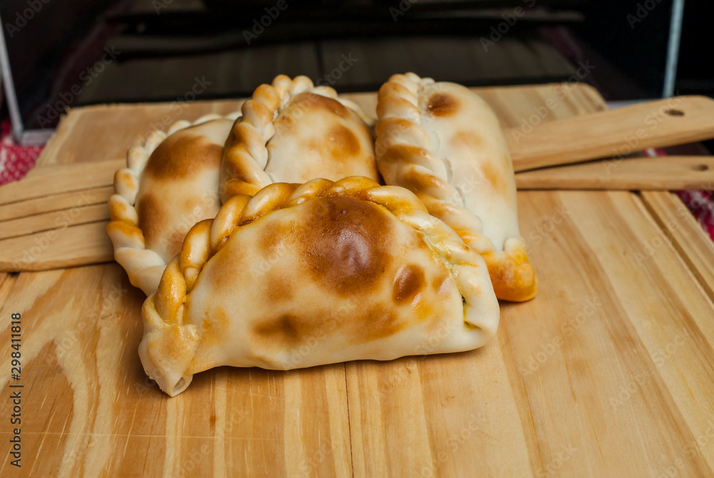 Wooden table with fresh homemade Empanadas (detailed close-up shot ...
