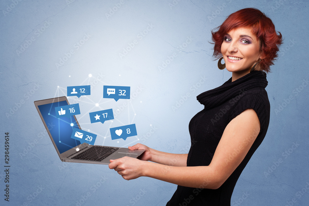 Woman holding laptop with different types of social media symbols and ...