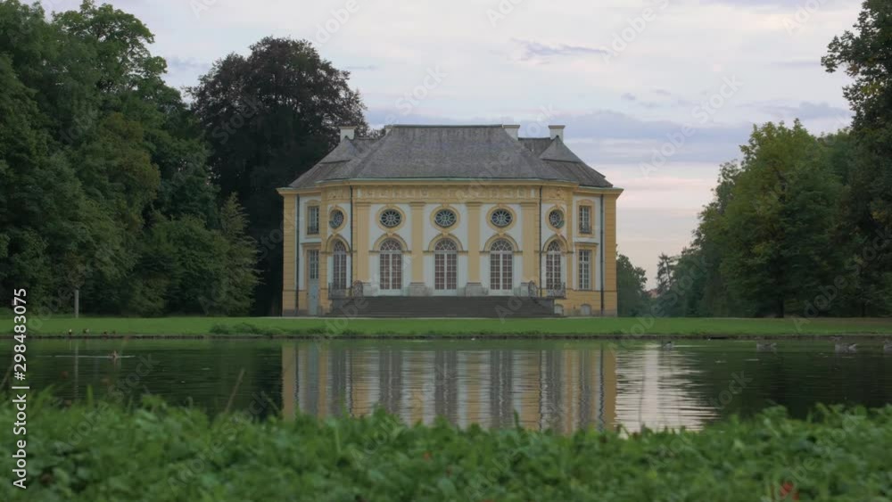 Old mansion by the water lake pond in forest with green trees two ...
