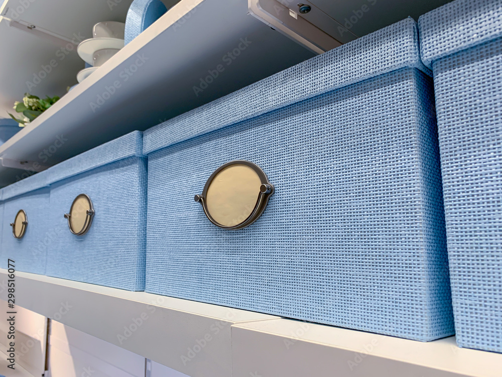 Rows of stacked blue storage carton boxes and home textyle stacked on ...