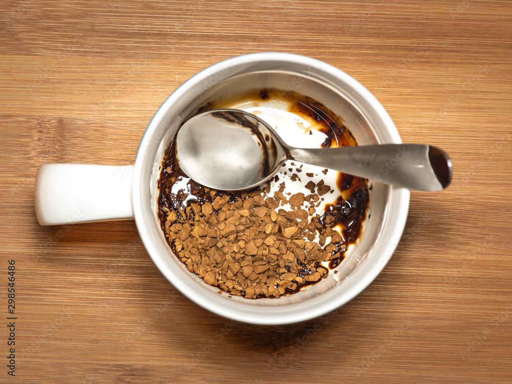 Instant Coffee in mug with spoon, freeze dried melting in bottom of cup ...
