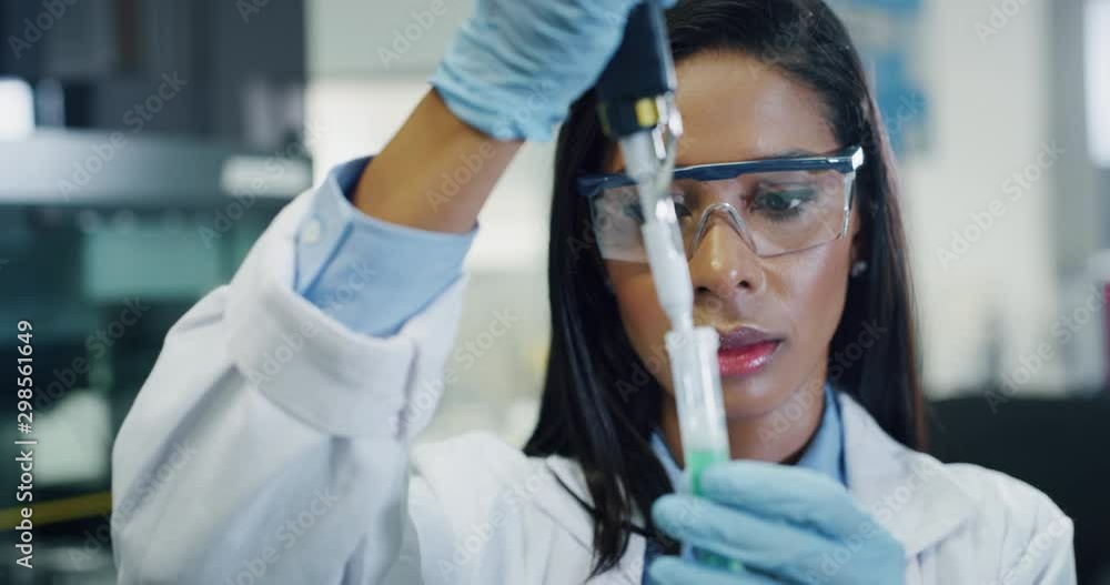Portrait of dark skin female scientist is analyzing with a pipette a ...