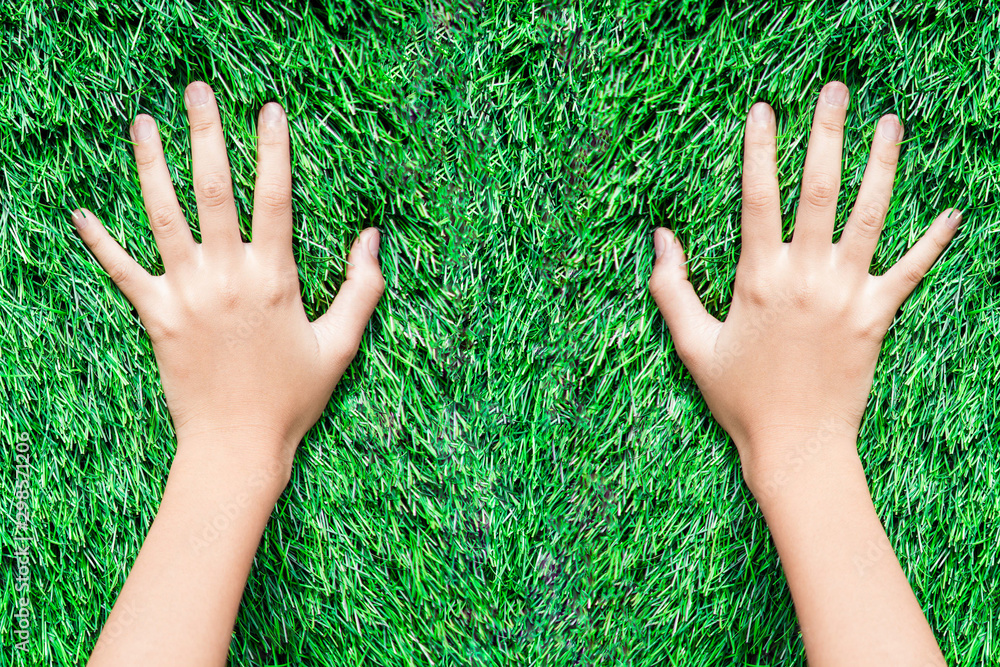 The hands of a girl put and touching with artificial grass.Sensory of ...