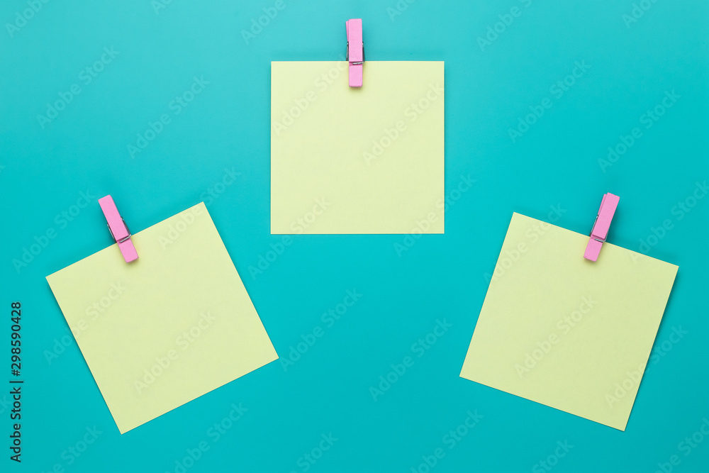 Sticky note with pink pin on turquoise background. Yellow stickers on a ...