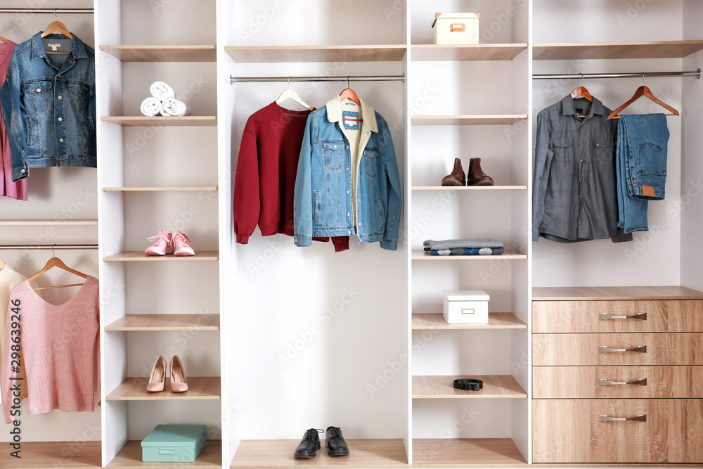 Big wardrobe with different clothes and accessories in dressing room ...