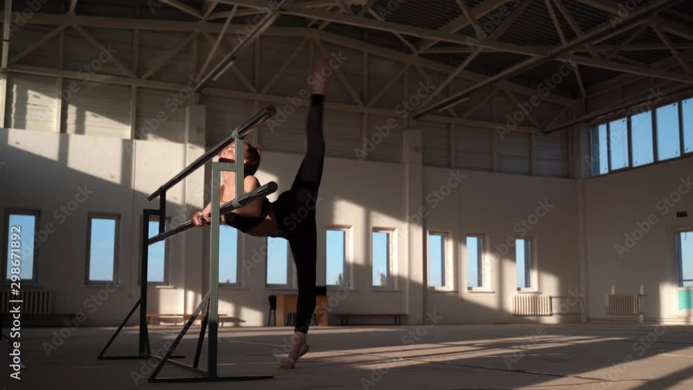 Charming sporty girl actively trains by metal bar, closes eyes with ...