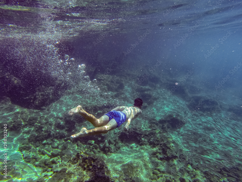 man dives into the depths of the sea without fins. freediving Stock ...