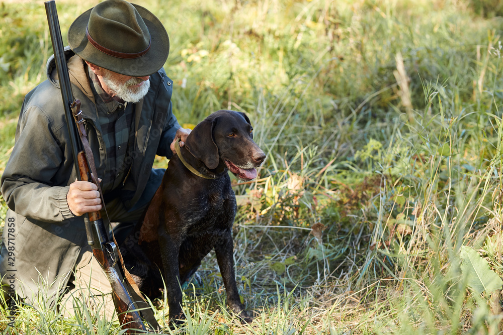 Senior hunter and his dog in forest, look for prey, hunting on wild ...