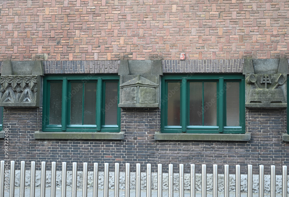 Grey and Red Brick Building with Decorative Window Dividers and Green ...