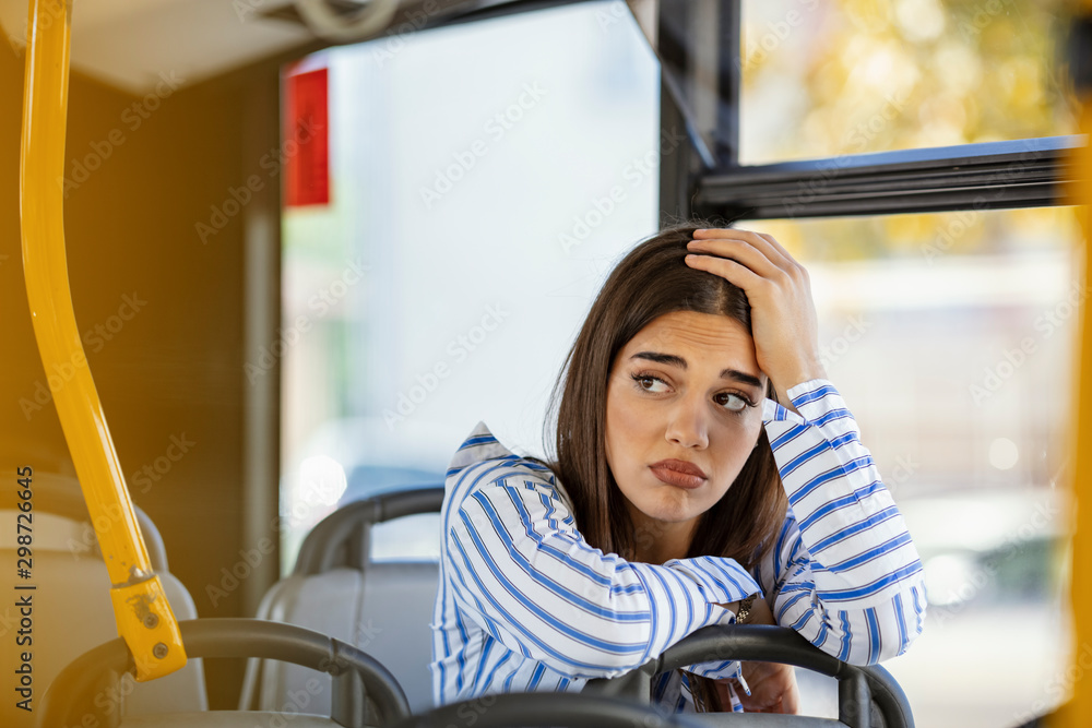 Worried young woman traveling inside of a bus. Beautiful sad woman ...
