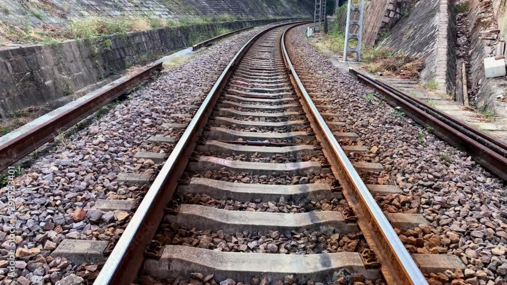 4K - The bending Railway line is carried over gravel and concrete ...