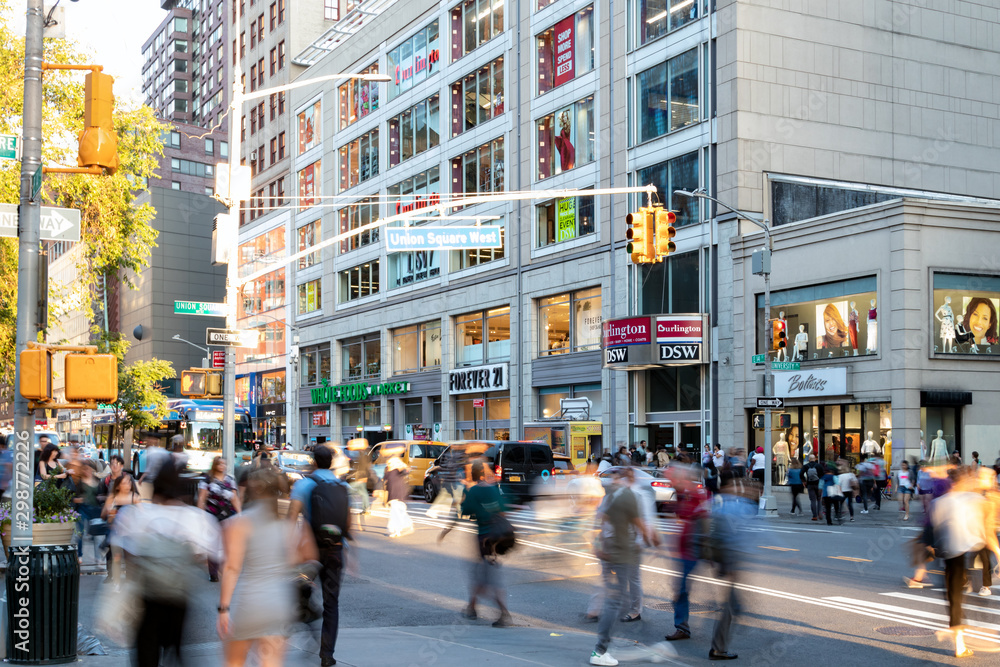 Diverse crowds of people walking through a busy intersection at 14th ...