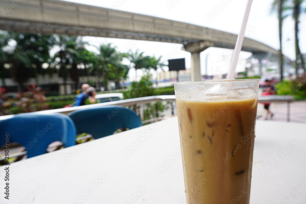 Milk Ice Tea or Teh Ais on top of table over urban cityscape ...