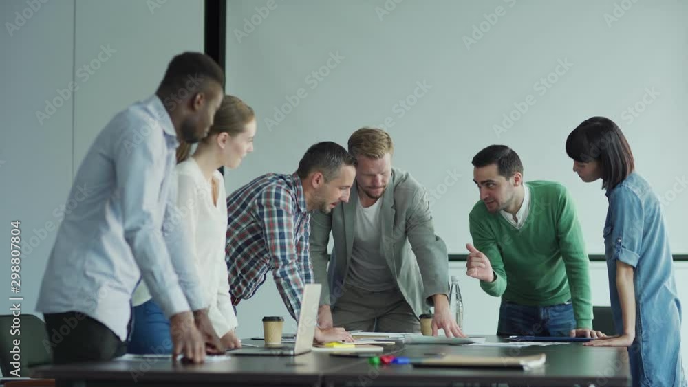 Group of diverse business people standing around table in meeting room ...