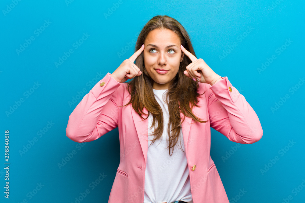 young woman looking concentrated and thinking hard on an idea ...