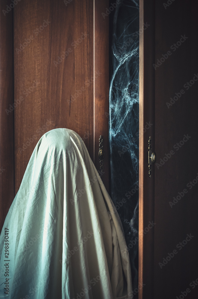 A ghost stands near an old creepy wardrobe. Halloween creature and ...