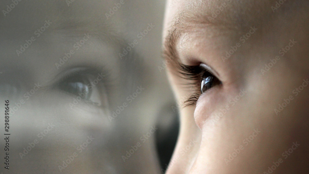 Little boy looking through window. Eye macro. Reflection of the face in ...