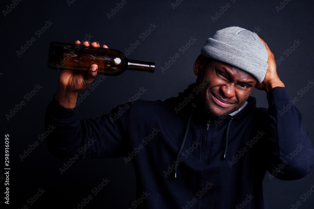 african american man holding a bottle of wine and feeling headache shit ...