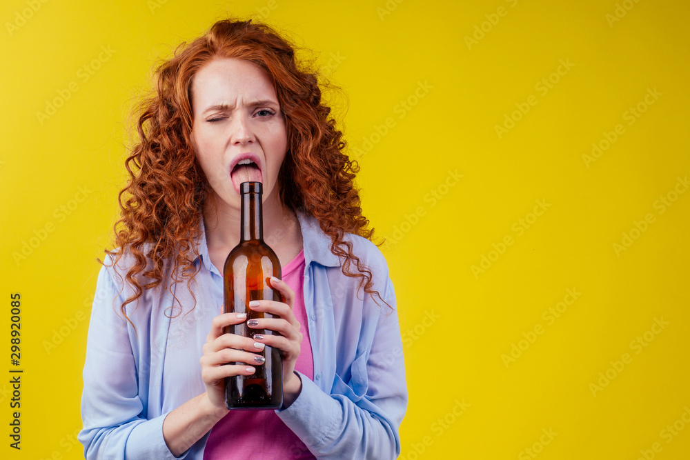 Curly Redhead Ginger Woman Drinking Beer And Feeling Bad Mood In Csudio Yellow Background Stock