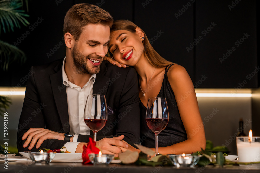 Excited loving couple celebrating special event with wine and candles ...