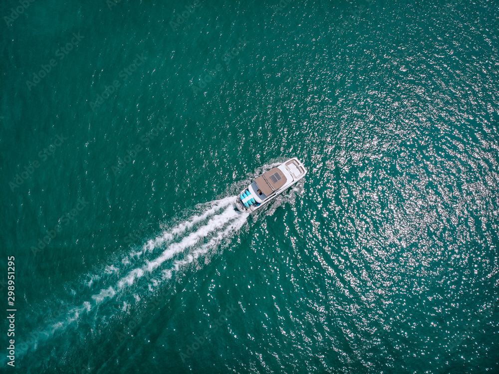 Bird eye view of the white motor boat moving fast, the vessel leaves a ...