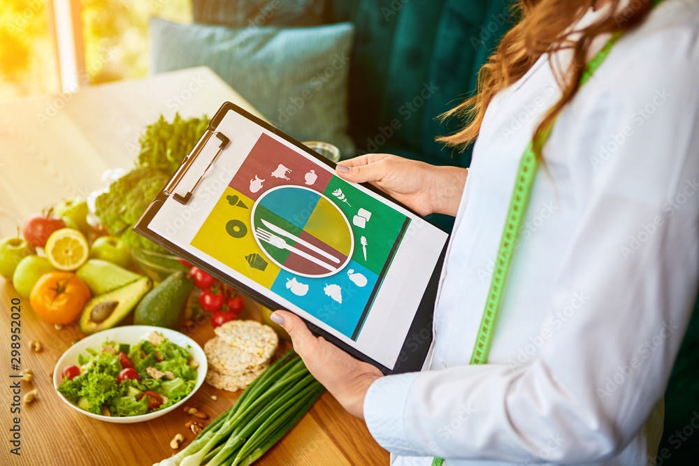 Holding schematic meal plan for diet with various healthy products on ...