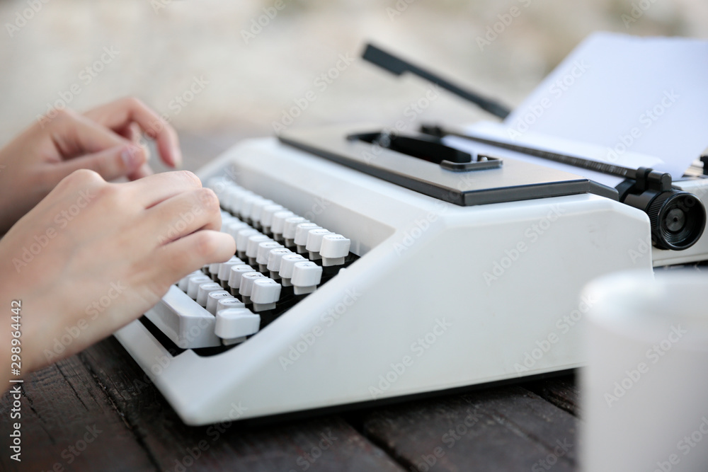 Manos de persona tecleando en máquina de escribir vintage en mesa de ...