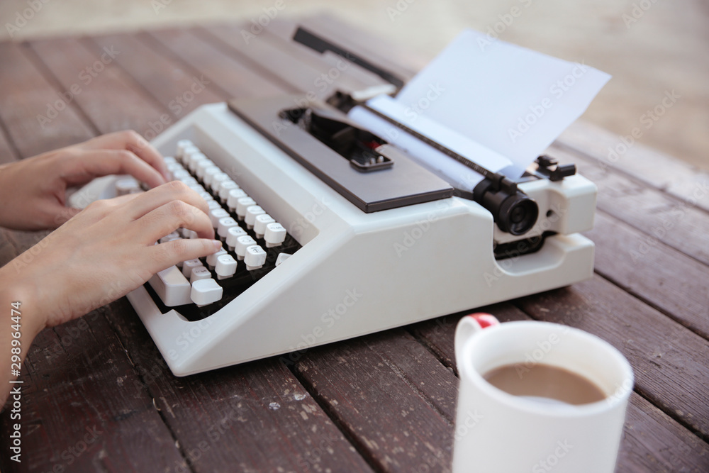 Manos de persona tecleando en máquina de escribir vintage en mesa de ...