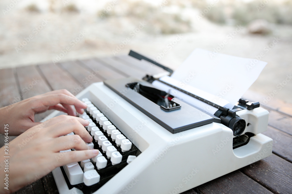 Manos de persona tecleando en máquina de escribir vintage en mesa de ...